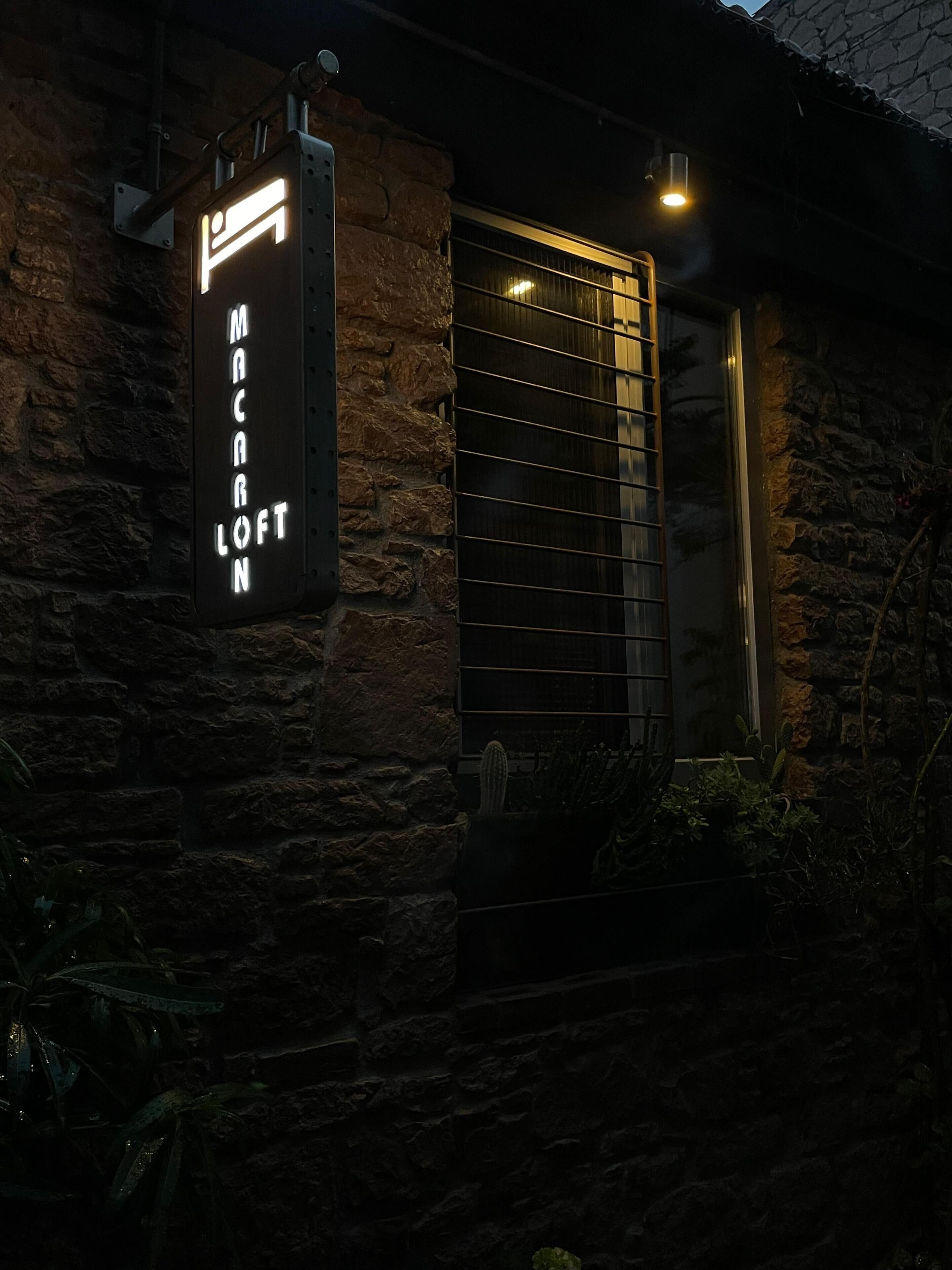 Um edifício de pedra com uma placa que diz "MACAR LOFT".