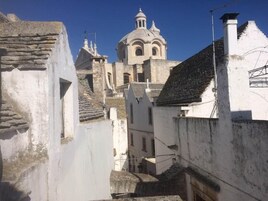 Uma rua estreita com edifícios de pedra e uma igreja com cúpula.