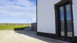 Um edifício moderno com uma parede de pedra e um espaço pavimentado.