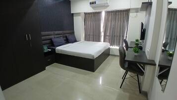 Quarto moderno com cama, escrivaninha e guarda-roupa.
