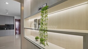 Uma cozinha moderna com geladeira de aço inoxidável, um armário de madeira e uma planta pendente.