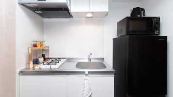 Um frigorífico/congelador grande, um micro-ondas, uma placa de cozinha