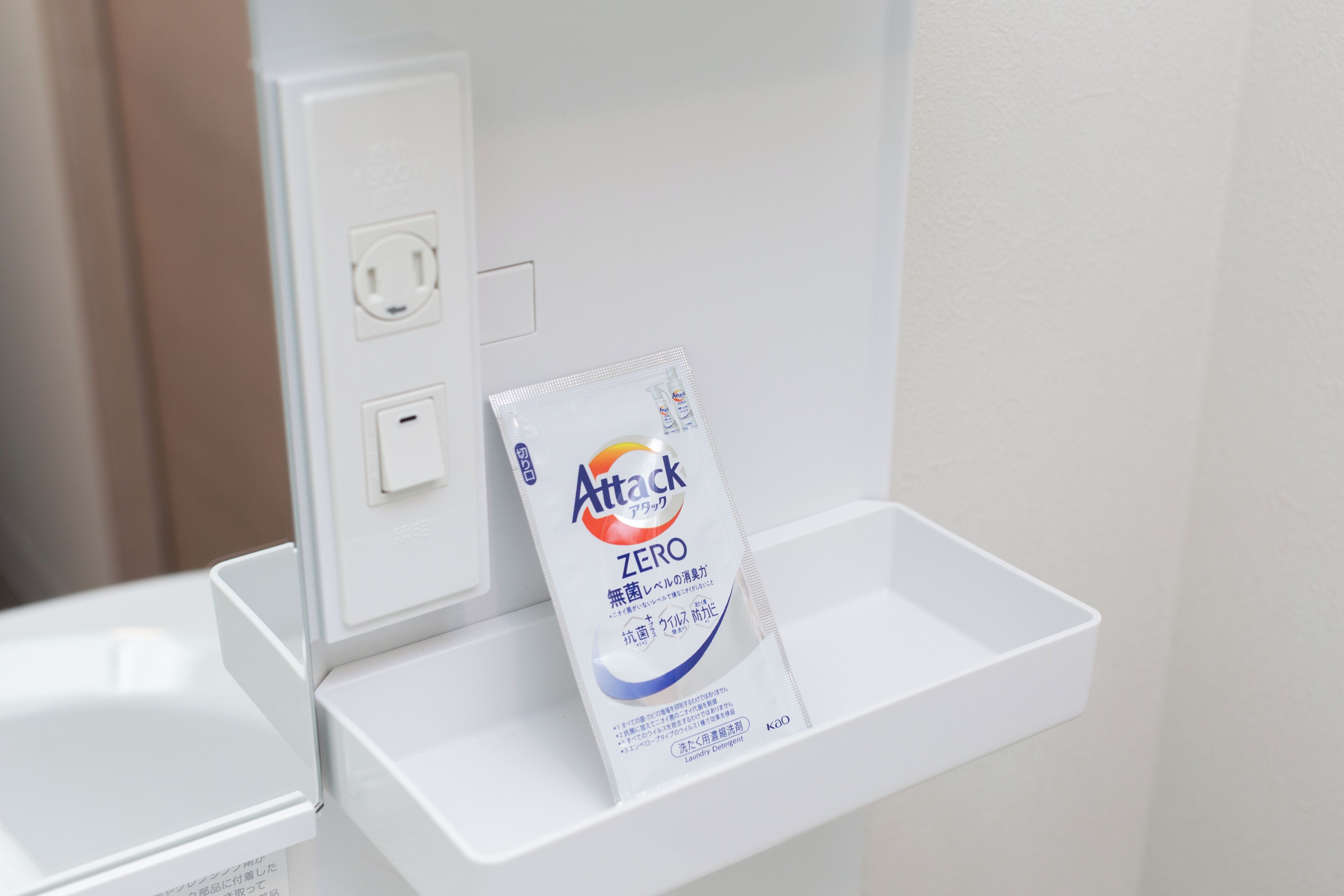 Uma prateleira branca com um pacote de detergente Attack Zero.
