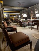 Uma área de estar moderna com sofás de couro, uma mesa de jantar e luminárias.