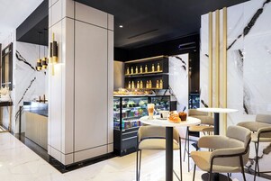 Um interior moderno com área de bar, assentos e uma variedade de bebidas engarrafadas.