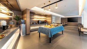 Cozinha moderna com sistema de buffet, incluindo mesa com comida e geladeira com compartimentos.