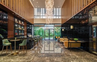 Uma área de bar moderna com piso de mármore polido, painéis de madeira e diversas opções de assento, incluindo banquetas e cadeiras.