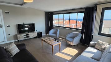 Suíte premium, sacada, vista para o mar | Área de estar