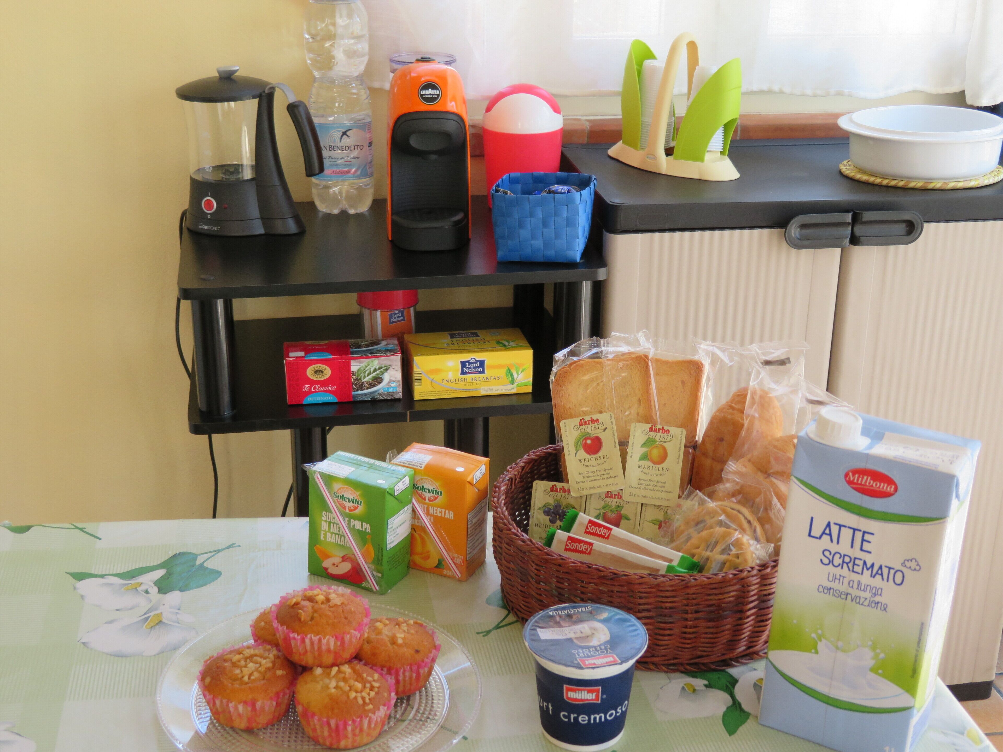 Uma bancada de cozinha com diversos alimentos e eletrodomésticos.
