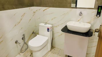 Quarto Triplo Deluxe | Casa de banho | Um polibã, toalhas fornecidas, sabão, champô