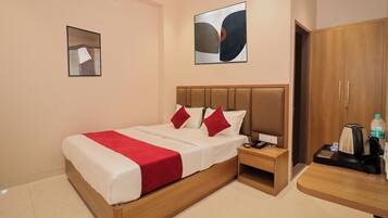 Quarto de hotel com cama, mesa de cabeceira e guarda-roupa.