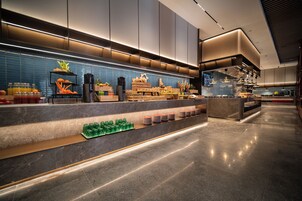 Uma cozinha moderna com bancada de mármore, forno embutido e espaço para café.