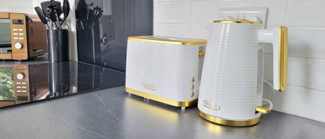 Cozinha equipada com micro-ondas, torradeira e máquina de café.