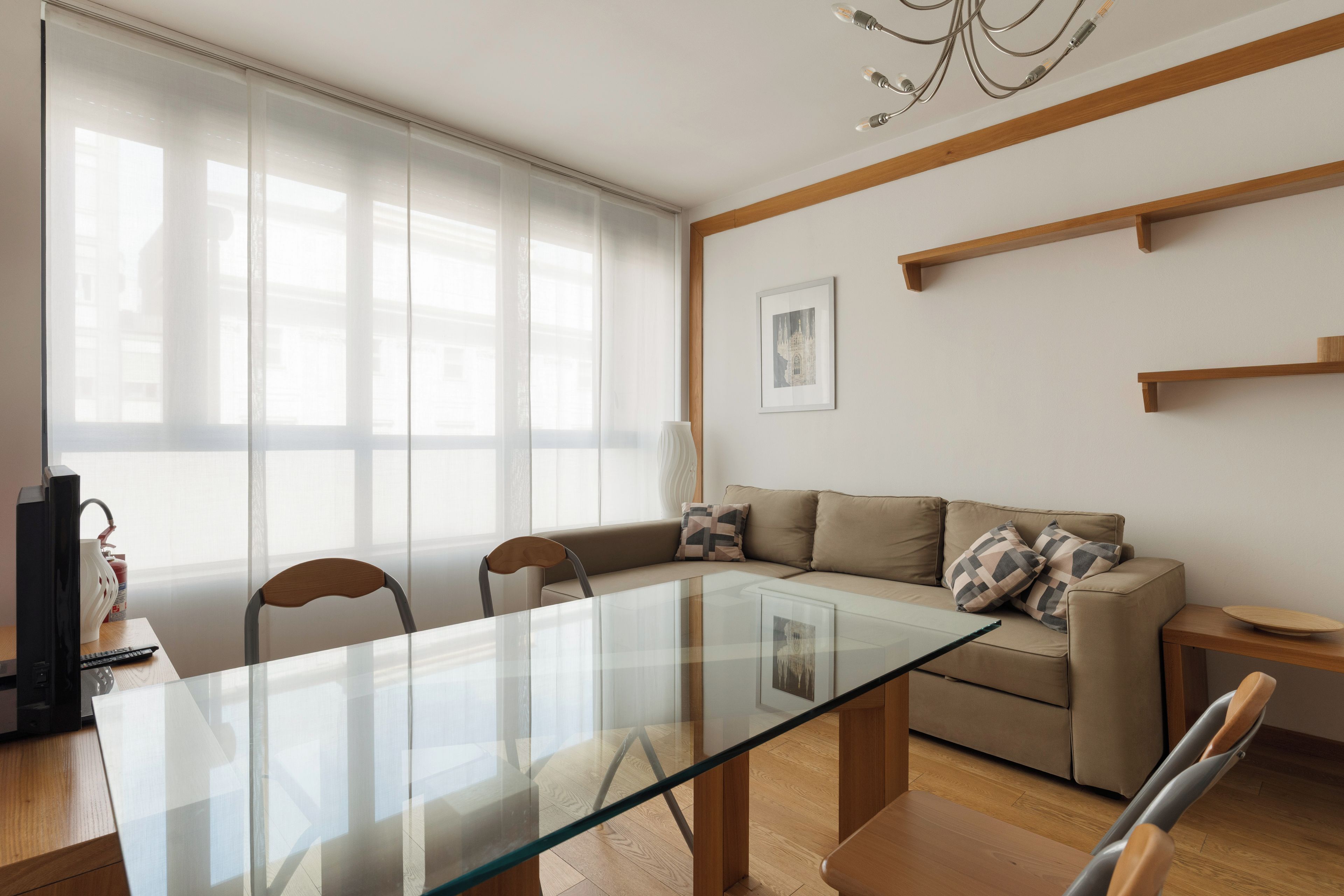 Uma sala de estar moderna com uma mesa de jantar de vidro, um sofá e uma lareira.