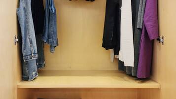 Um closet espaçoso com sapatos organizados, um banco e diversas peças de roupa.