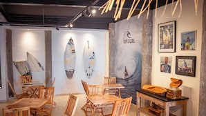 Quarto com móveis de madeira, pranchas de surf e um mural com um surfista.