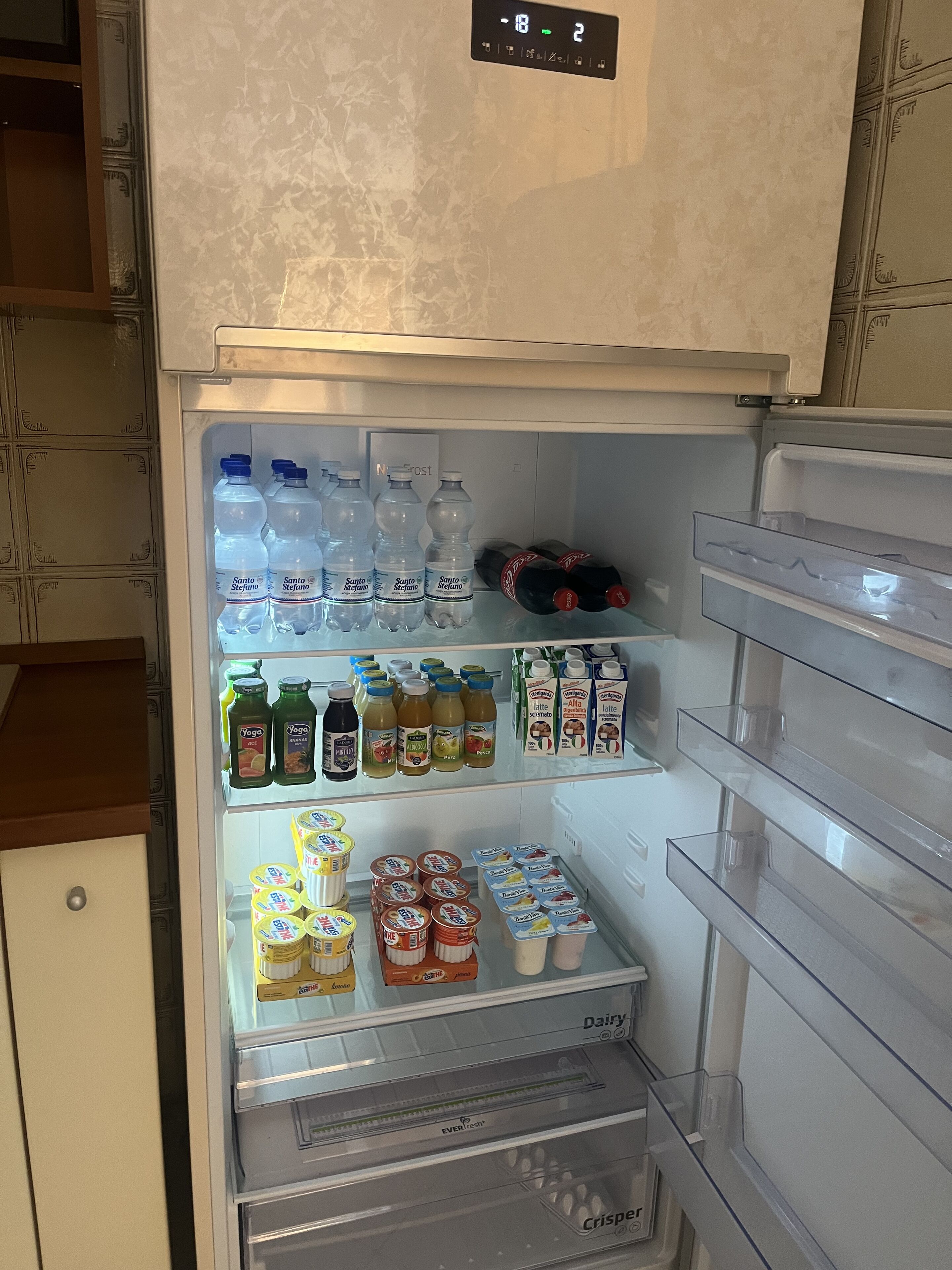 Geladeira com diversas bebidas e produtos lácteos.