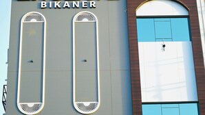 Placa de hotel com o nome 'HOTEL ENCLAVE BIKANER' e um logotipo.