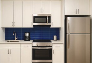 Um frigorífico/congelador grande, um micro-ondas, um forno 