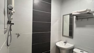 Um secador de cabelo, toalhas fornecidas, sabão, champô