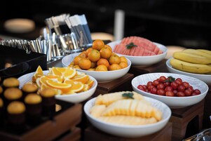 Diversas frutas e acompanhamentos dispostos sobre uma mesa.