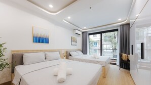 Quarto de hotel com duas camas, varanda com vista e uma janela grande.