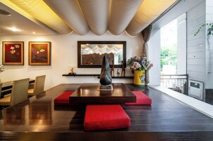 Um interior moderno com área de refeições, um espelho grande e vista para o exterior.