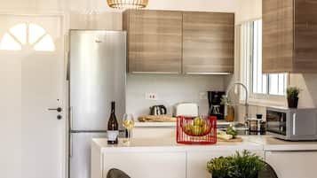 Um micro-ondas, uma cafeteira/bule, utensílios de cozinha