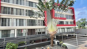 Um edifício moderno com vários andares, grandes janelas e fachada em vermelho e branco.