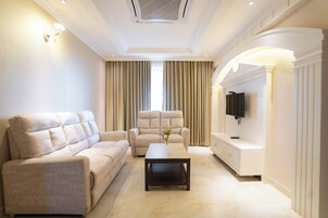 Uma sala de estar moderna com sofá, poltrona e mesa de centro.
