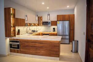 Apartamento luxo | Cozinha privada | Frigobar, cooktop, talheres/pratos/utensílios de cozinha