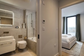 Apartamento, 1 cama king-size | Casa de banho | Uma combinação polibã/banheira, artigos de higiene pessoal grátis