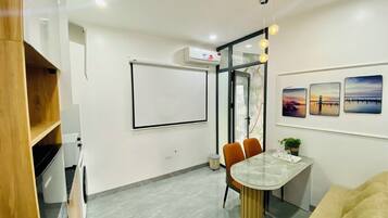 Apartamento Deluxe, 1 cama queen-size, varanda, Vista para a cidade | Sala de estar | Televisor de ecrã plano de 50 polegadas com canais digitais, Netflix