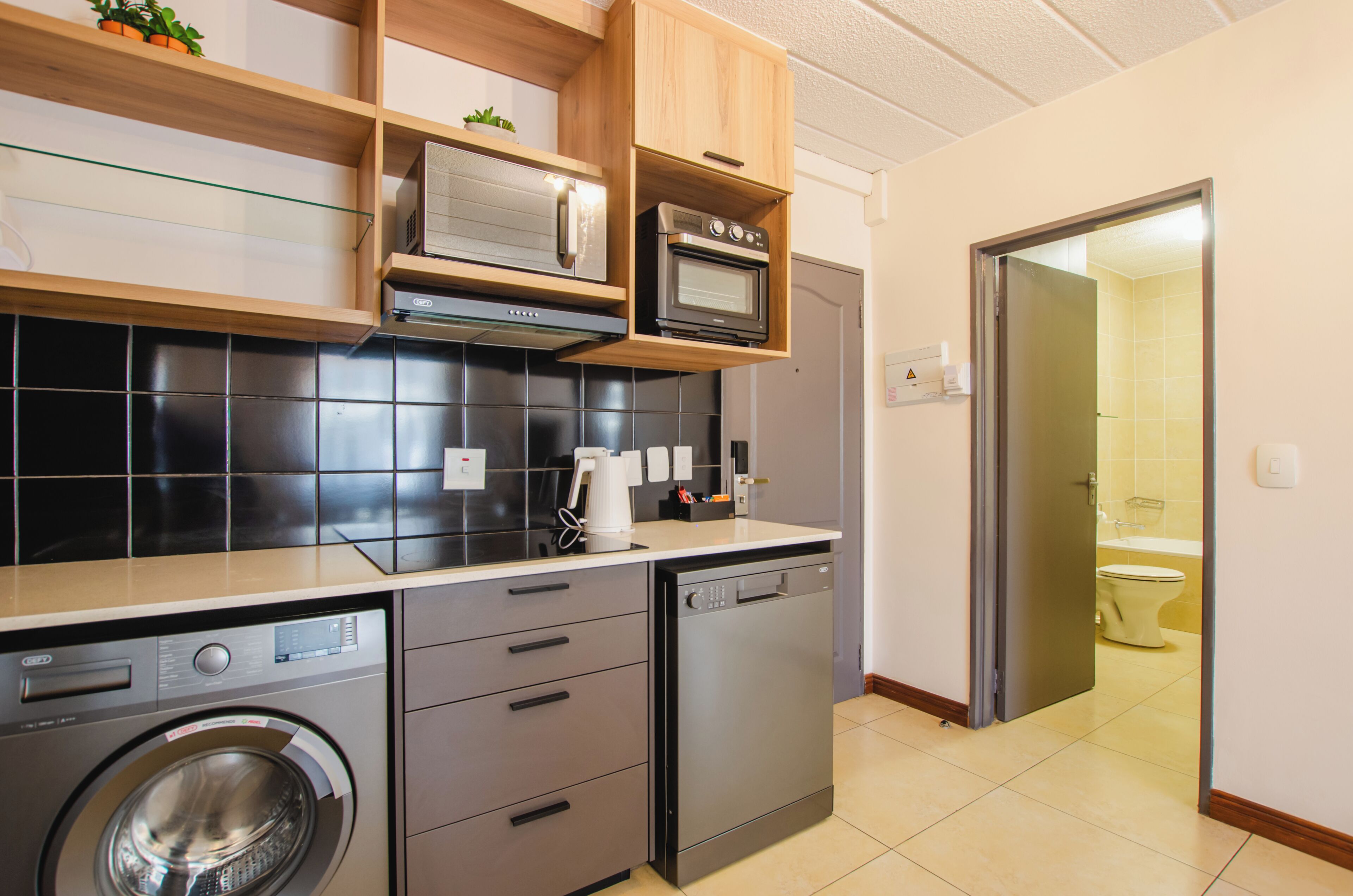 Uma cozinha compacta equipada com máquina de lavar, lava-louças, micro-ondas e forno.