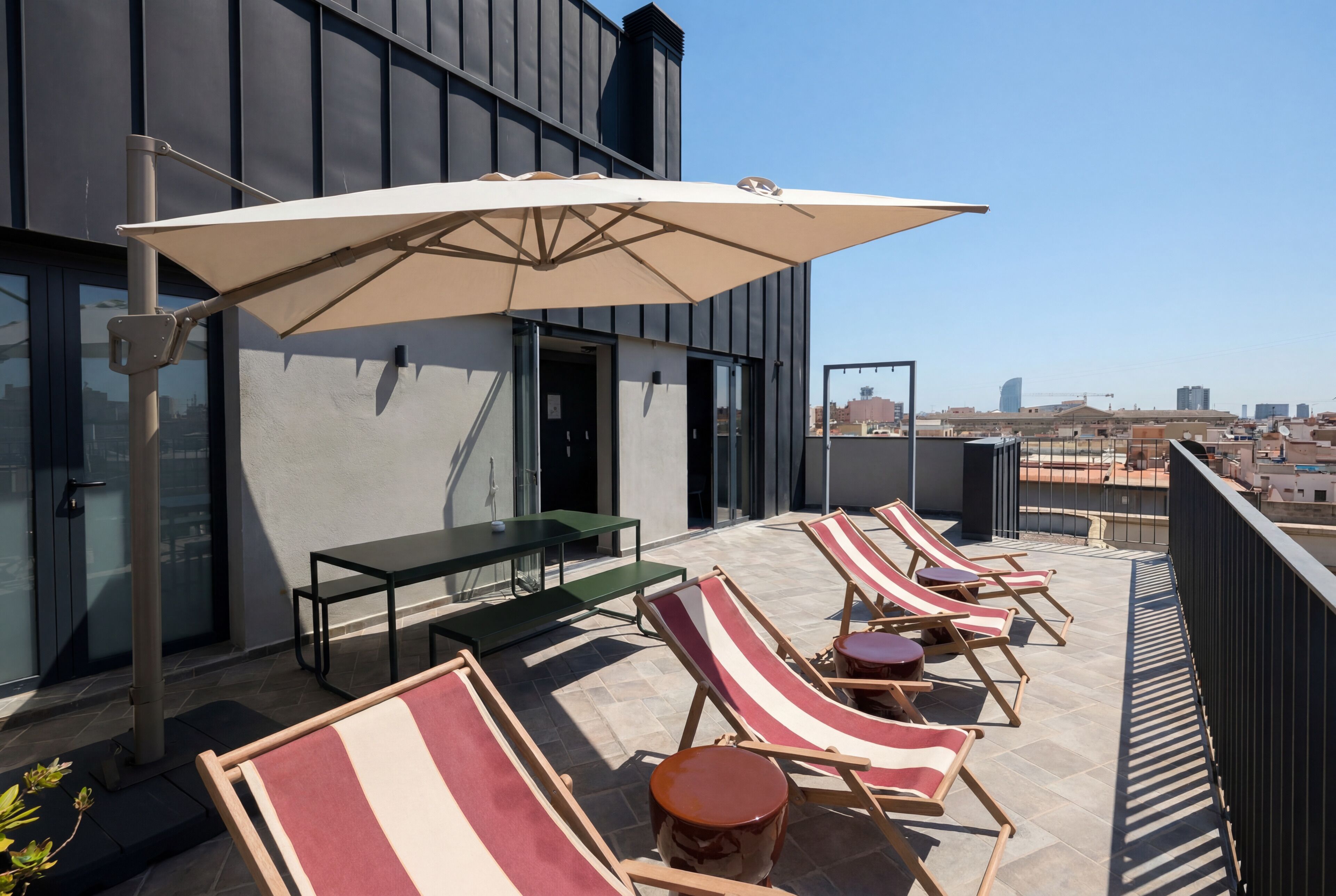 Terraço no telhado com cadeiras de estar, uma mesa e um guarda-sol.