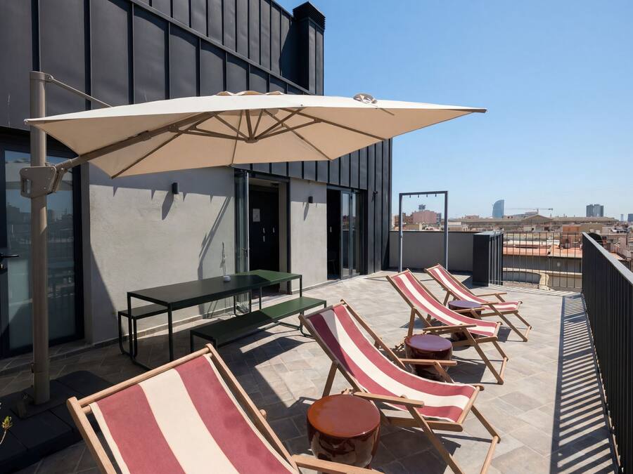 Terraço no telhado com cadeiras de estar, uma mesa e um guarda-sol.