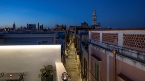 Terraço no telhado com vista para o horizonte urbano, incluindo uma torre imponente.