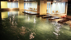 Piscina interna com água cristalina, várias pistas de natação e cadeiras ao longo das bordas.