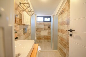 Apartamento, sacada, vista para a piscina | Banheiro | Chuveiro, secador de cabelo, chinelos, toalhas de banho