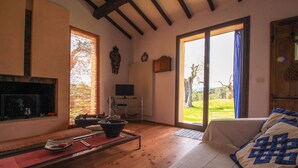 Uma sala de estar aconchegante com lareira, um sofá e uma grande janela com vista para o exterior.