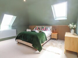 Um quarto com uma cama, mesa de cabeceira e janela.
