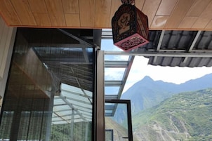 Quarto com uma grande porta de vidro que dá para a vista da montanha.
