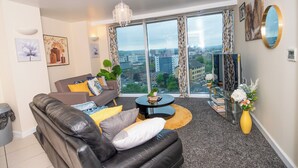 Uma sala de estar moderna com um sofá de couro, uma mesa de centro e uma janela grande com vista para a cidade.