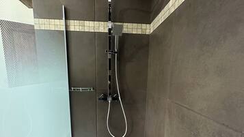 Um chuveiro moderno com um chuveiro manual e um chuveiro fixo na parede.