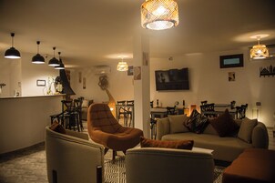 Uma sala de estar moderna com sofá, poltronas e um espaço de jantar.