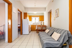 Um espaço compacto com cozinha compacta, um sofá e uma área de refeições.