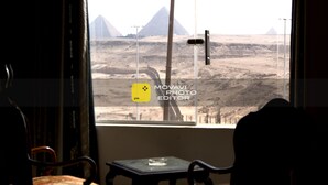 Quarto com vista para as pirâmides através de uma janela.