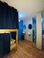 Um quarto com beliches, pia e espelho.