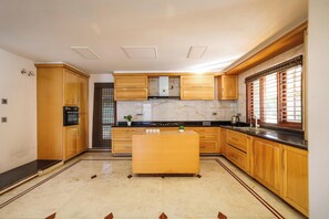 Cozinha moderna com armários de madeira, bancada de mármore e uma ilha central.