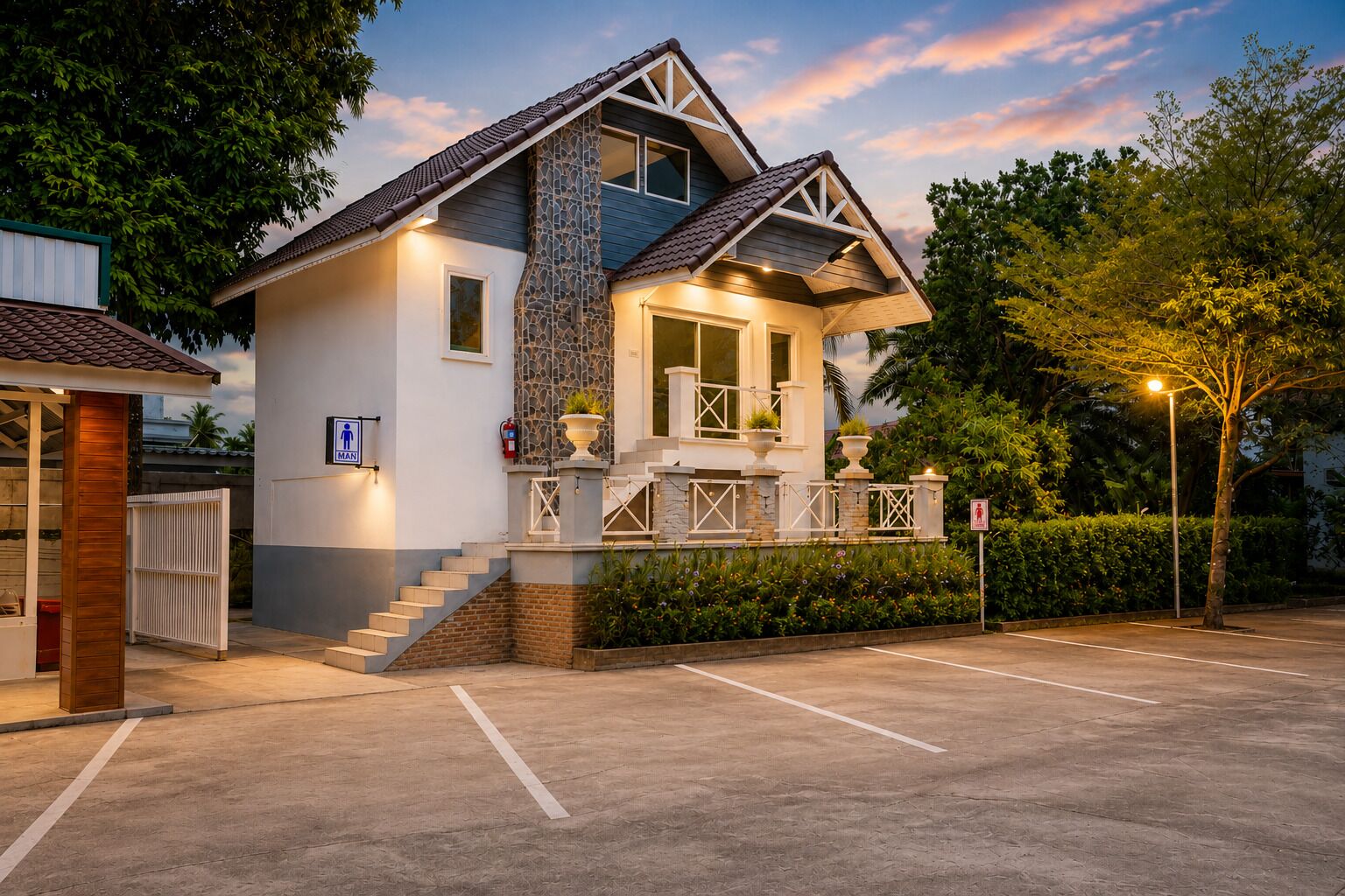 Uma casa de dois andares com fachada de pedra, uma varanda com grades e uma garagem.